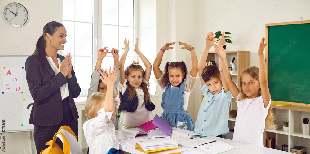 Happy teacher and children playing games and having fun in class ...