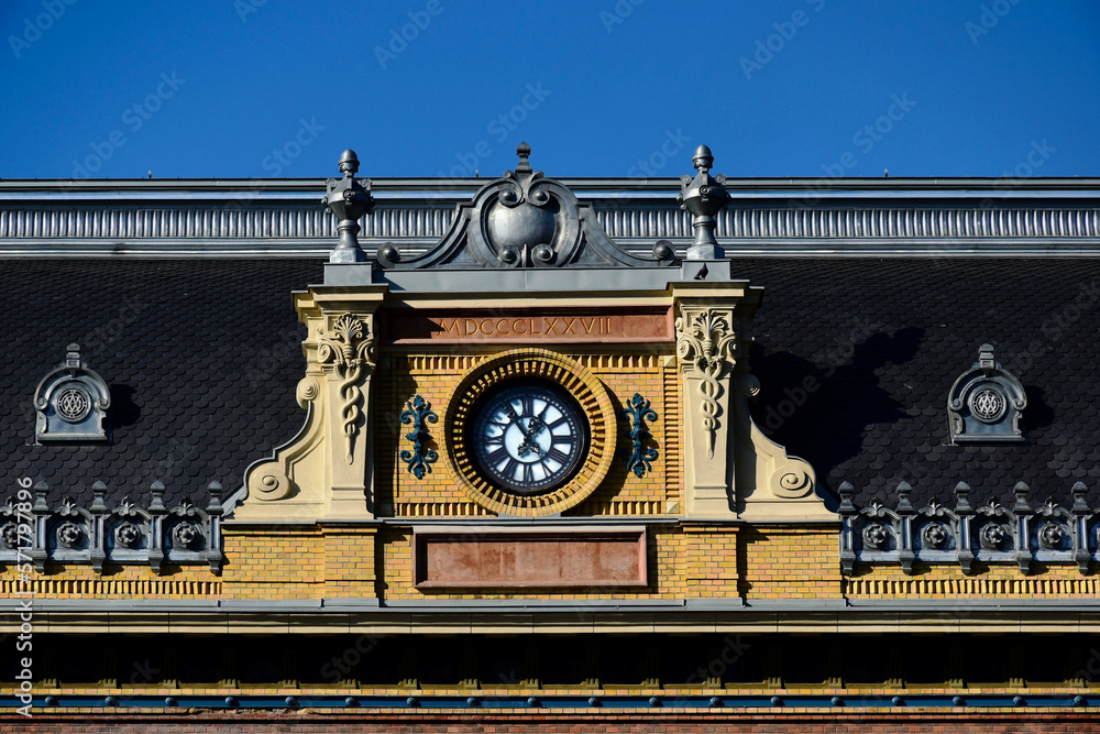 large white round clock in decorative exterior yellow brick wall in ...