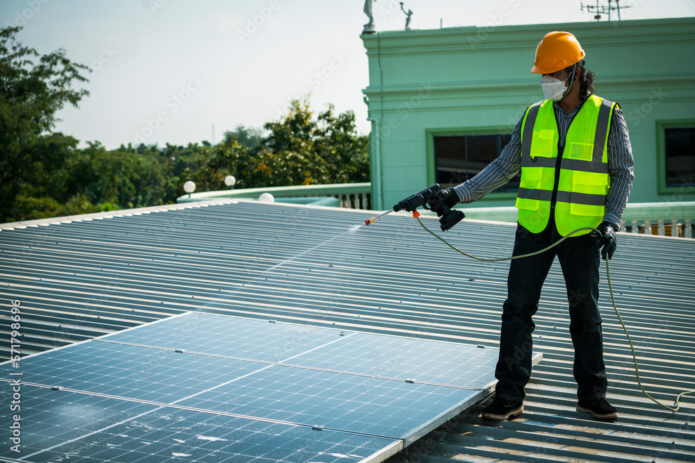 Maintenance technician using high pressure water to clean the solar ...