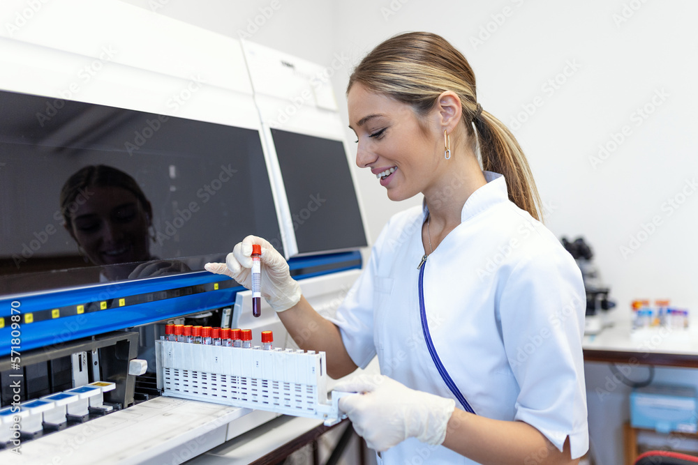 Lab tech loading samples into a chemistry analyzer. female lab tech ...