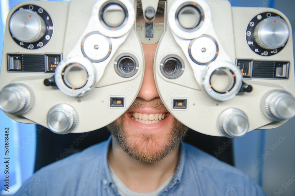 Handsome young man is checking the eye vision in modern ophthalmology ...