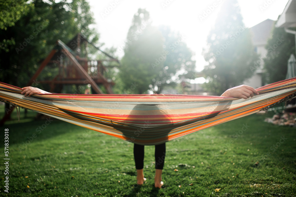 Tween girl taking a break while swinging in hammock in backyard Stock ...