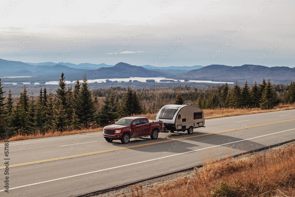 Pickup truck and RV camper drive along scenic road in Jackman, Maine ...