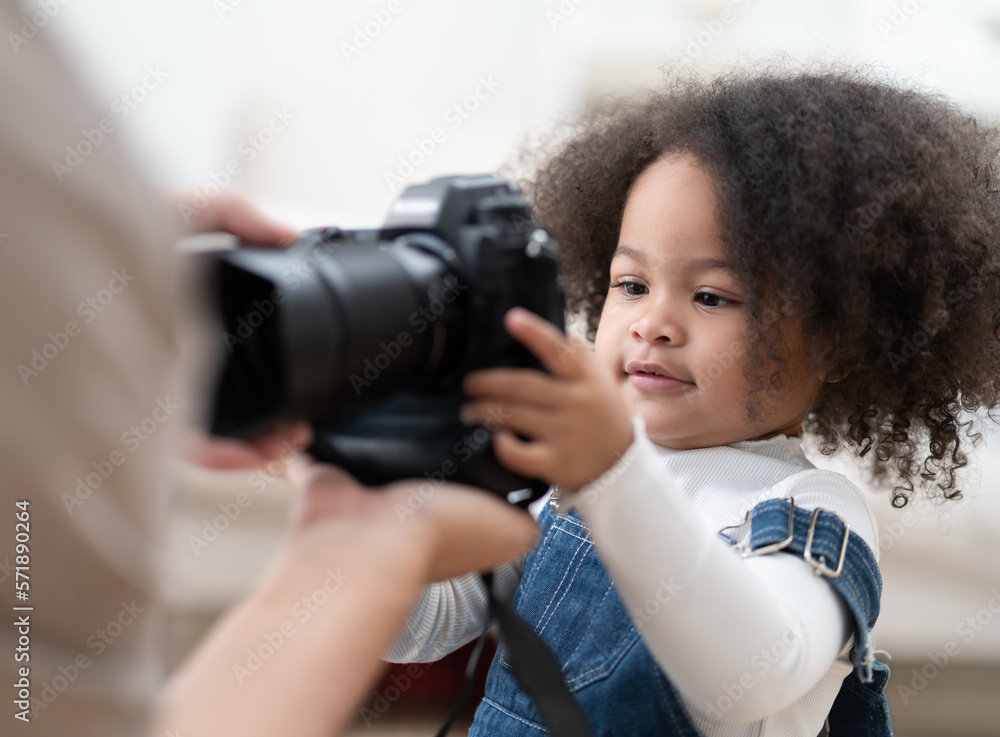 Cute little girl holding camera with smile. Portrait of playful ...
