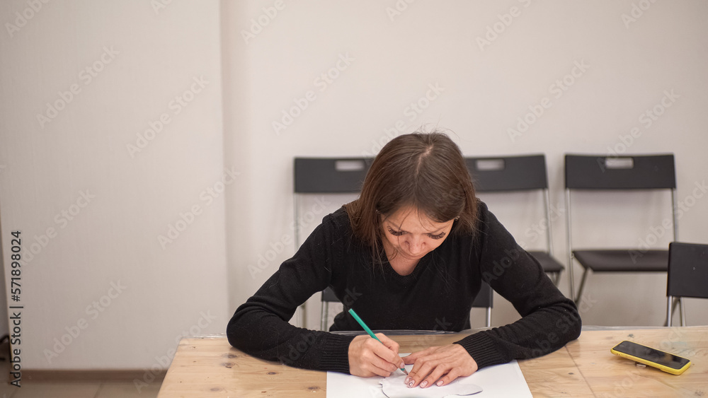 the girl draws on paper with a pencil. the girl erases the eraser to ...