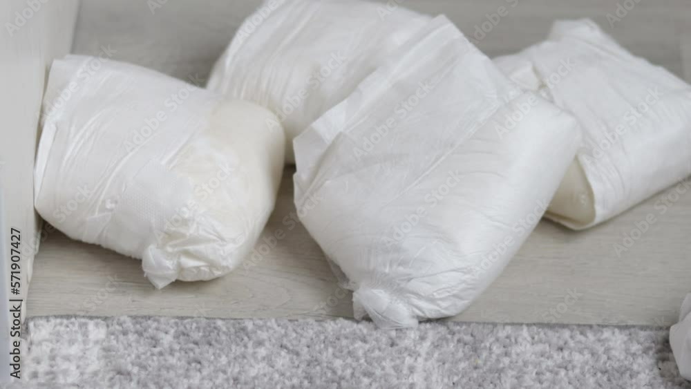 many dirty full baby diapers on floor bed or in blue trash plastic bag ...