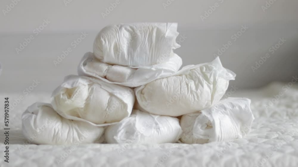 many dirty full baby diapers on floor bed or in blue trash plastic bag ...