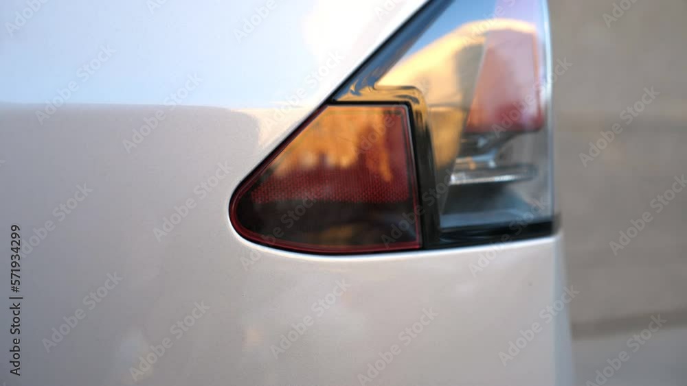 Hand opening an electric car charging socket cap and plugging in a ...