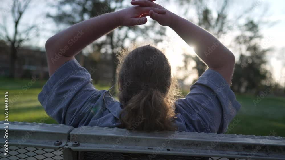 Back of a relaxed young man sitting at park bench enjoying nature and ...