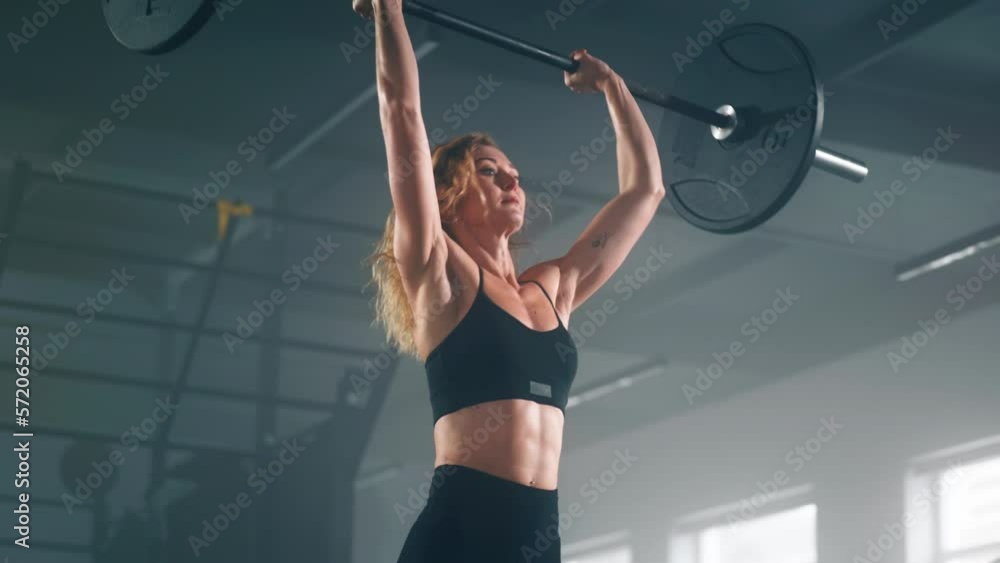 Portrait of a beautiful woman gaining lean arm biceps to improve her ...
