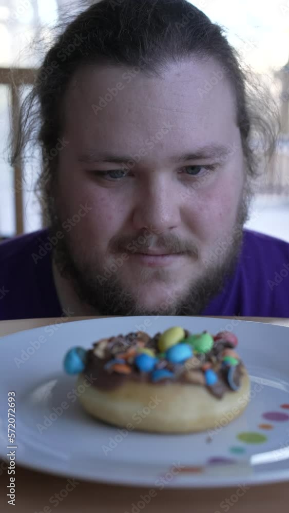 Overweight Person wanting to eat sugar food on plate. One Young fat man ...