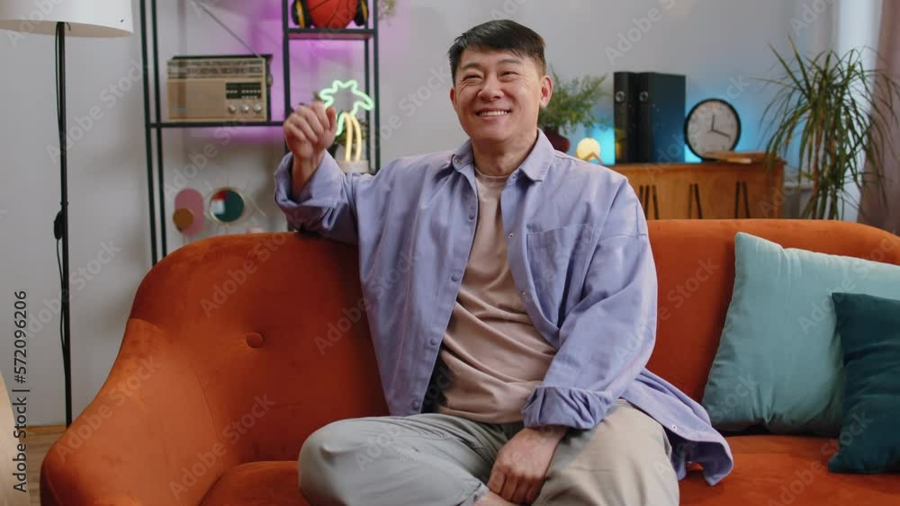 Portrait of happy calm asian man at home couch smiling friendly, glad ...