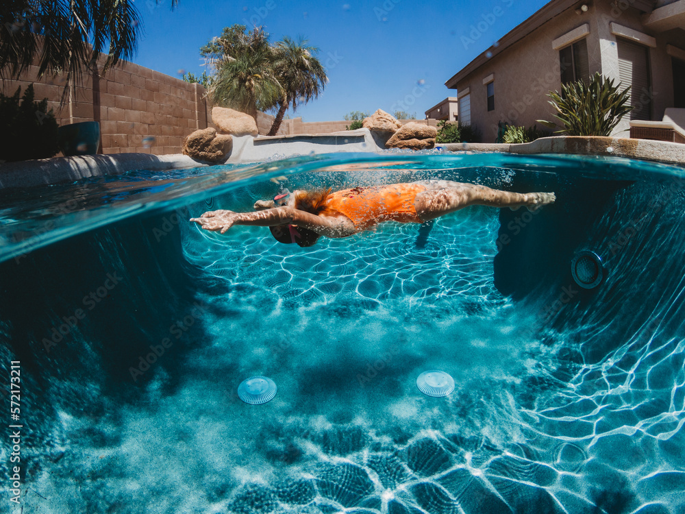 Girl floating under water in pool Stock Photo | Adobe Stock