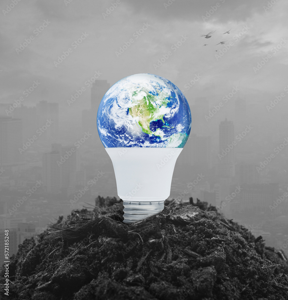 Earth globe inside led light bulb on soil over pollution city tower and ...