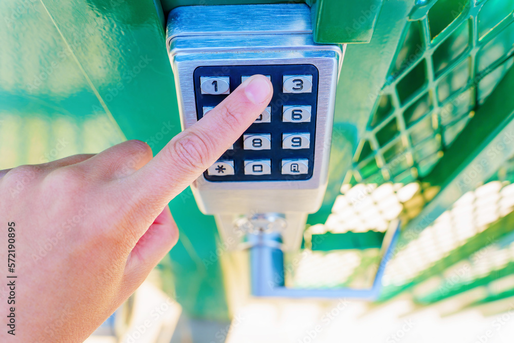 Hand enters a numeric code to open the gate lock Stock Photo | Adobe Stock