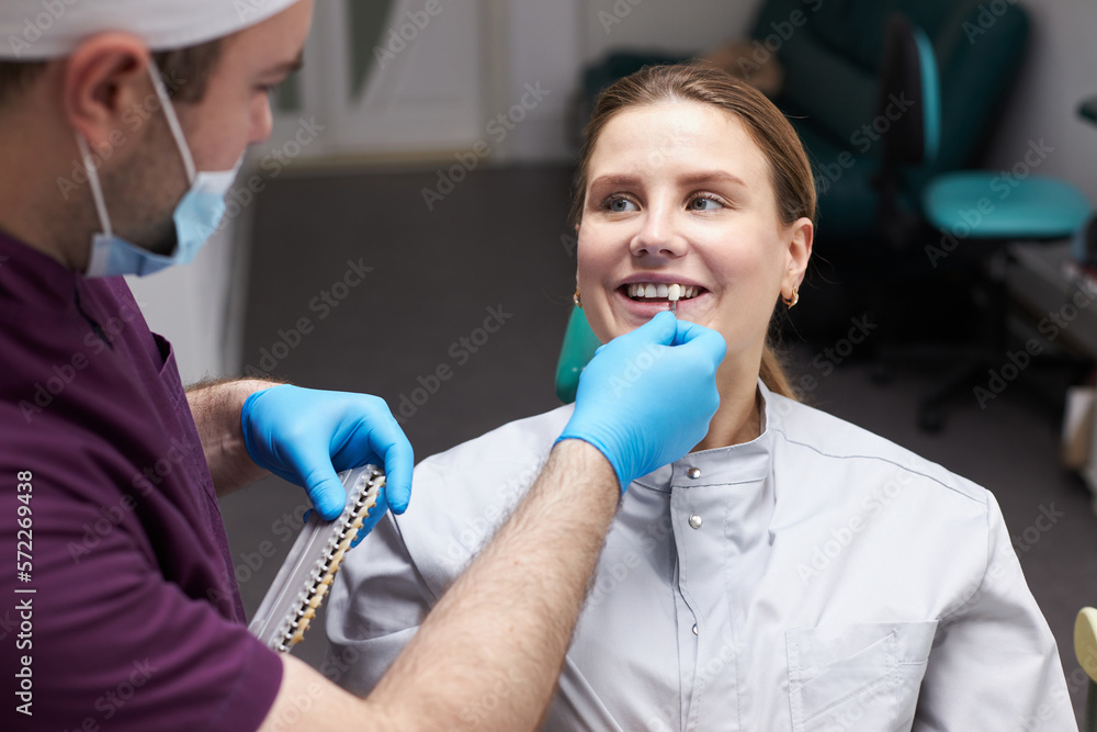 Doctor checks the color of tooth according to the comparative scale of ... Doctor checks the color of tooth according to the comparative scale of ...
