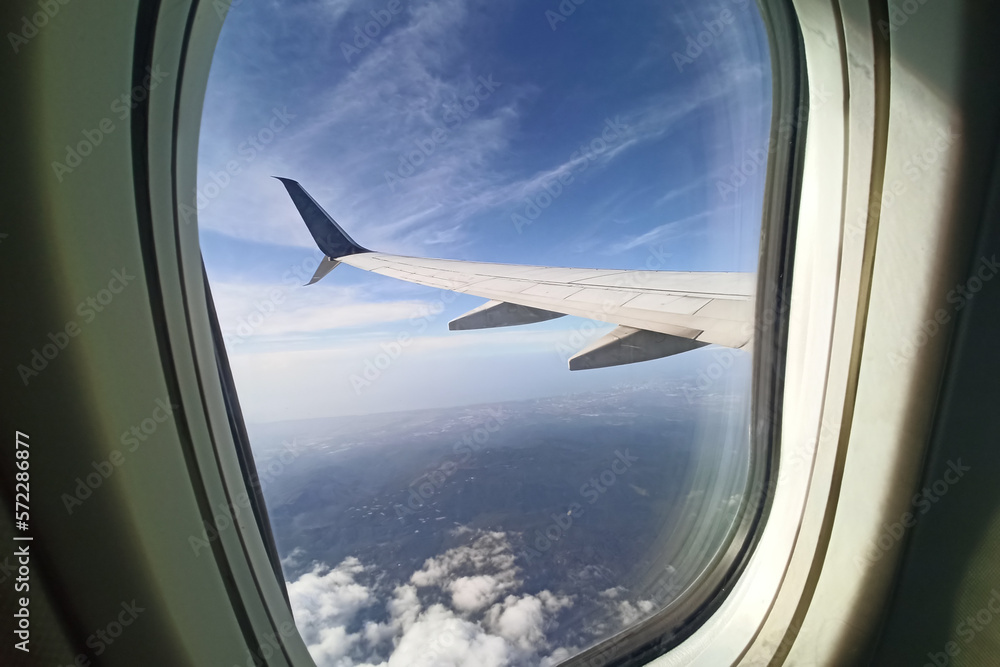View through airplane window of commercial jet plane wing flying high ...