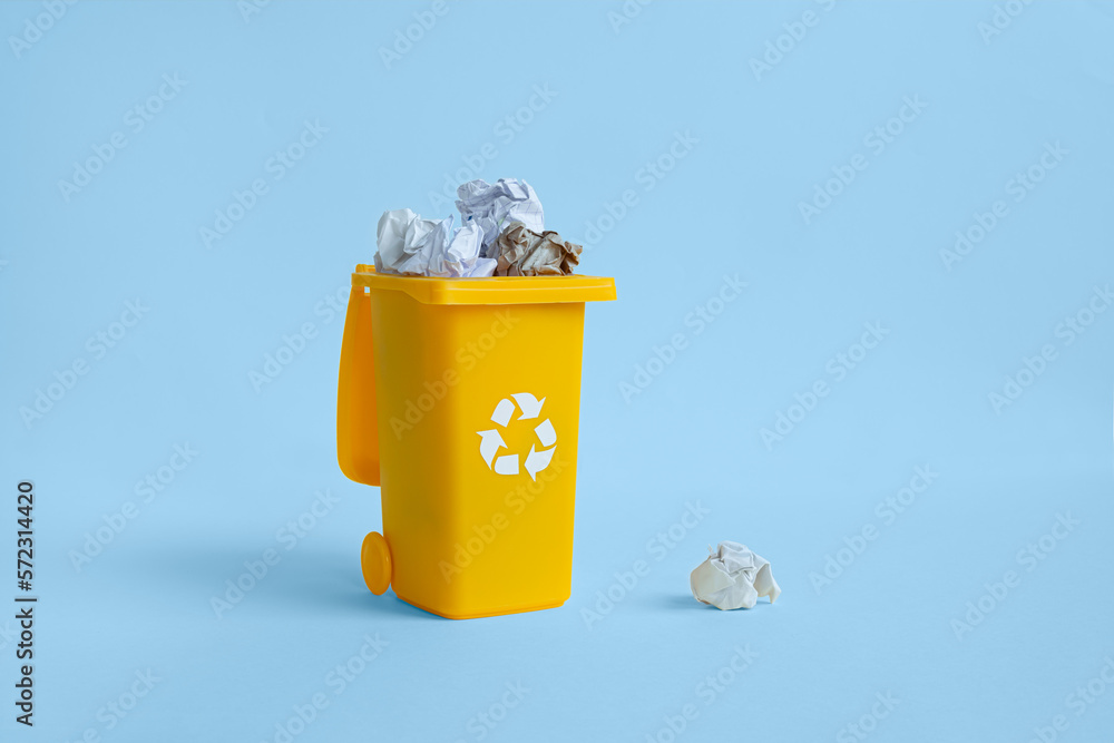 Almost closed container with paper waste isolated on the blue ...