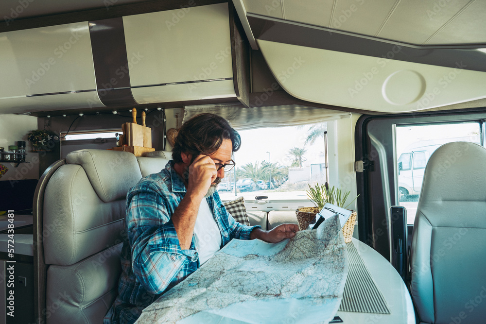 One traveler man alone inside a camper van looking for roads and ...