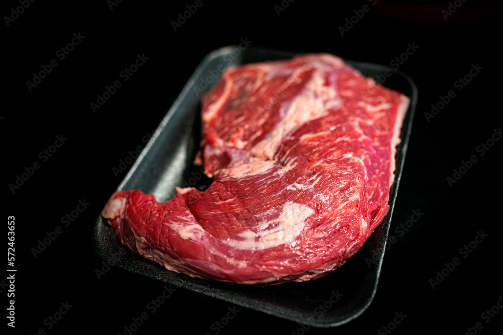 Packaged raw uncooked beef black angus tri tip steak closeup with black ...