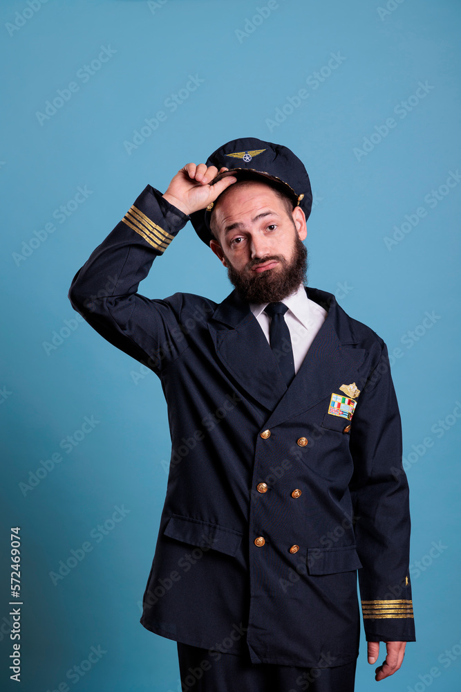 Airplane capitan taking hat off, looking at camera with confused facial ...