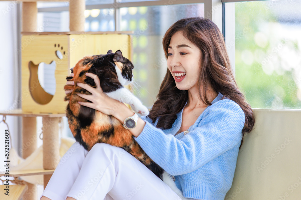 Millennial Asian cheerful young female owner sitting smiling holding ...