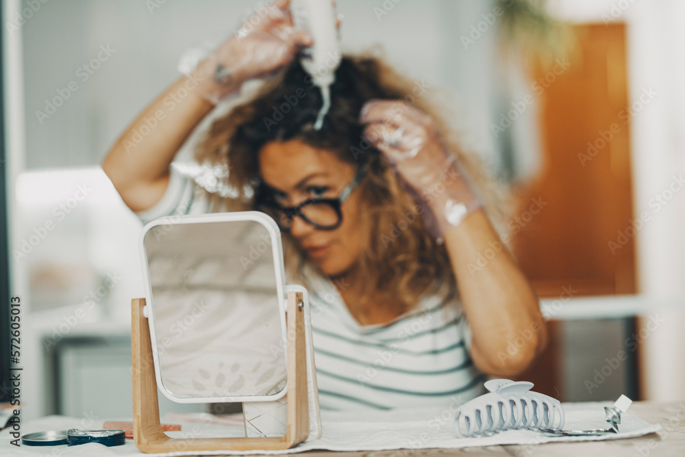 One alone woman in background putting cream treatment on her brown hair ...