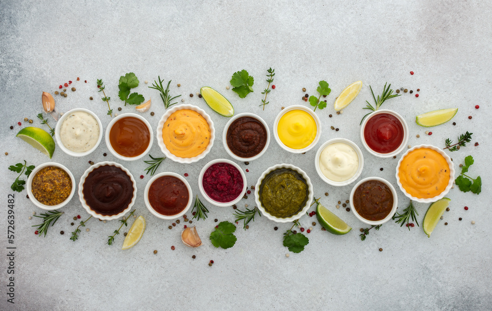 Different types of sauces in bowls with seasonings, rosemary and pepper ...