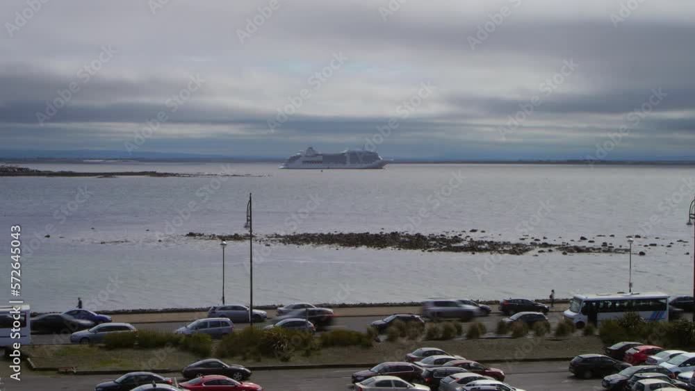 Time lapse. Pedestrians and cars pass by in Salthill Promenade. An ...