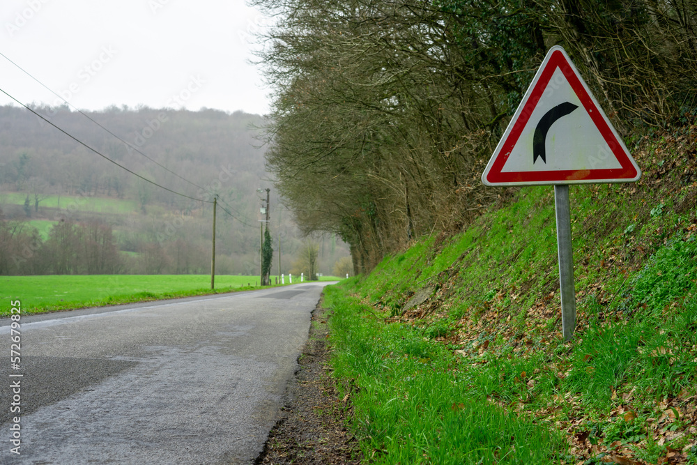 Road and road sign warning about a turn in the road. Road safety ...