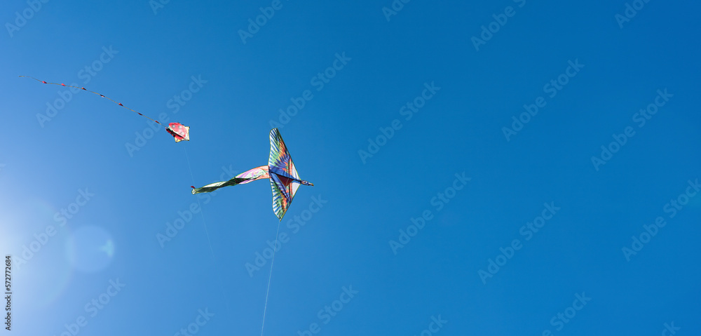 Colorful kite soars high in the sky Blue sky. Sports kite festival ...