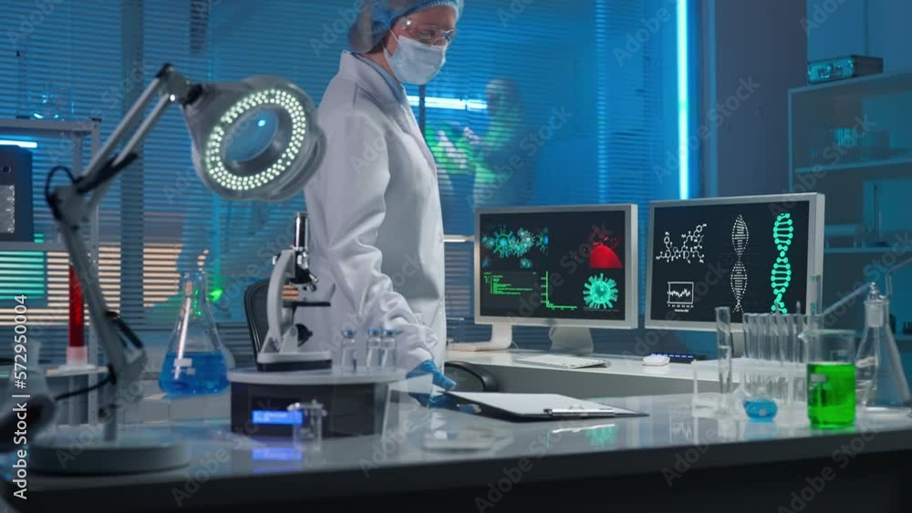 Medical development laboratory. A female scientist types on a keyboard ...