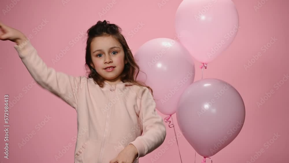 Cheerful Caucasian little child girl wearing pink pastel clothes ...