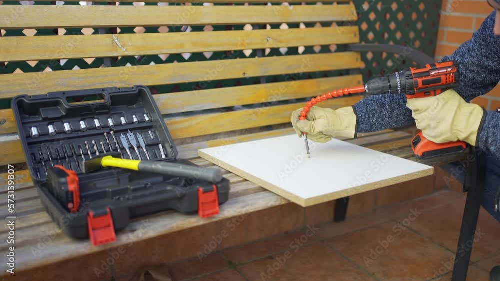 Man screwing a screw with a drill and a flexible drill bit to reach any ...