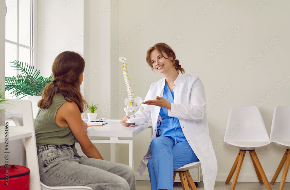 Spine specialist tells teenage girl about structure of spine during ...