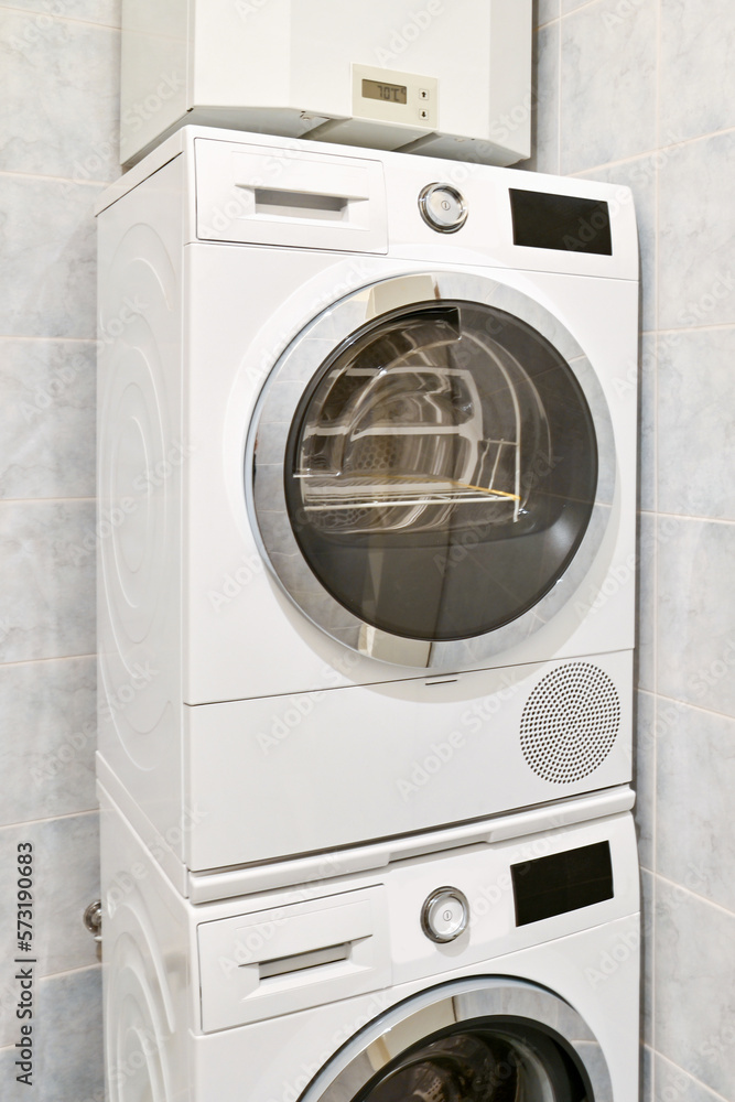 Washing machines and a clothes dryer stand on top of each other in a ...