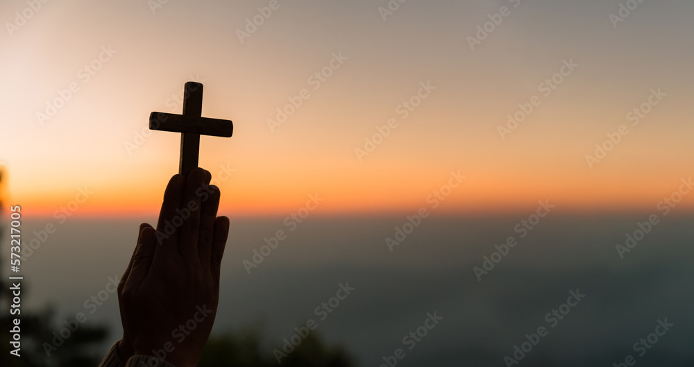 Foto Stock Silhouette of young woman kneeling down praying and holding ...
