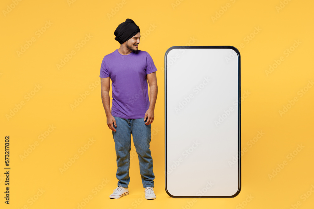 Full body happy devotee Sikh Indian man ties his traditional turban ...