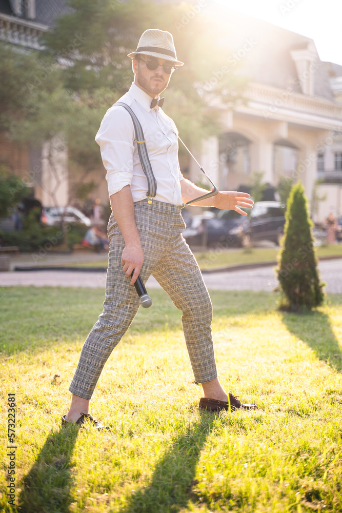 handsome presenter and showman in a stylish suit and hat with a ...