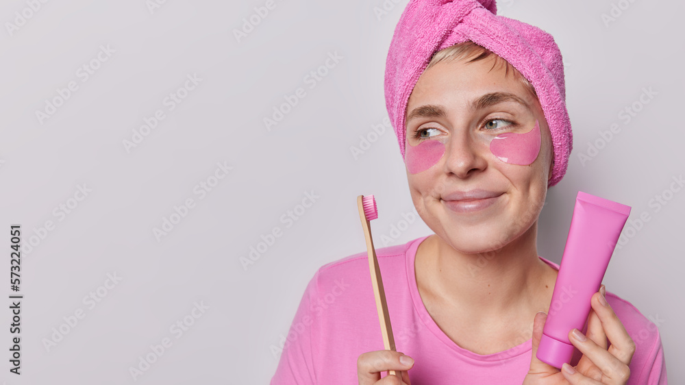 Pleased Young Woman Smiles Gently Has Dimples On Cheeks Holds