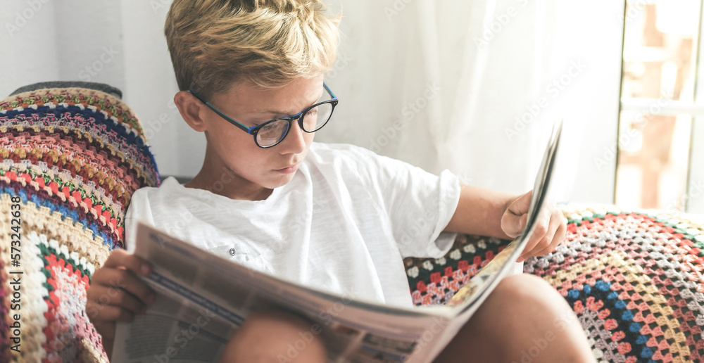 Young boy reading a newspaper at home. Child reads news. Information ...