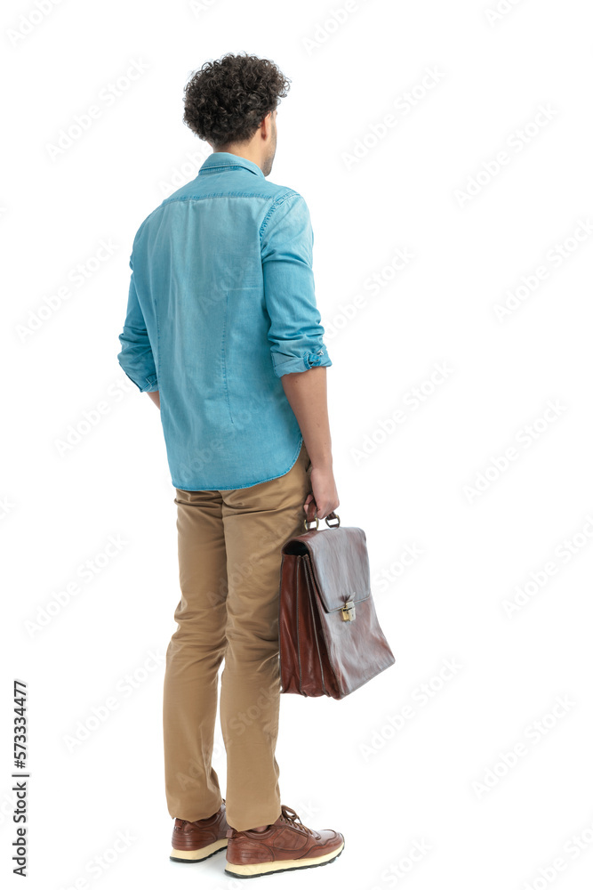 behind view of casual man with suitcase standing and posing Stock Photo ...