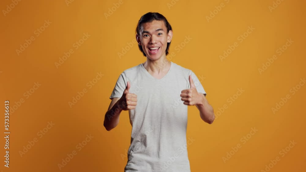 Carefree guy giving thumbs up on camera, expressing agreement and okay ...