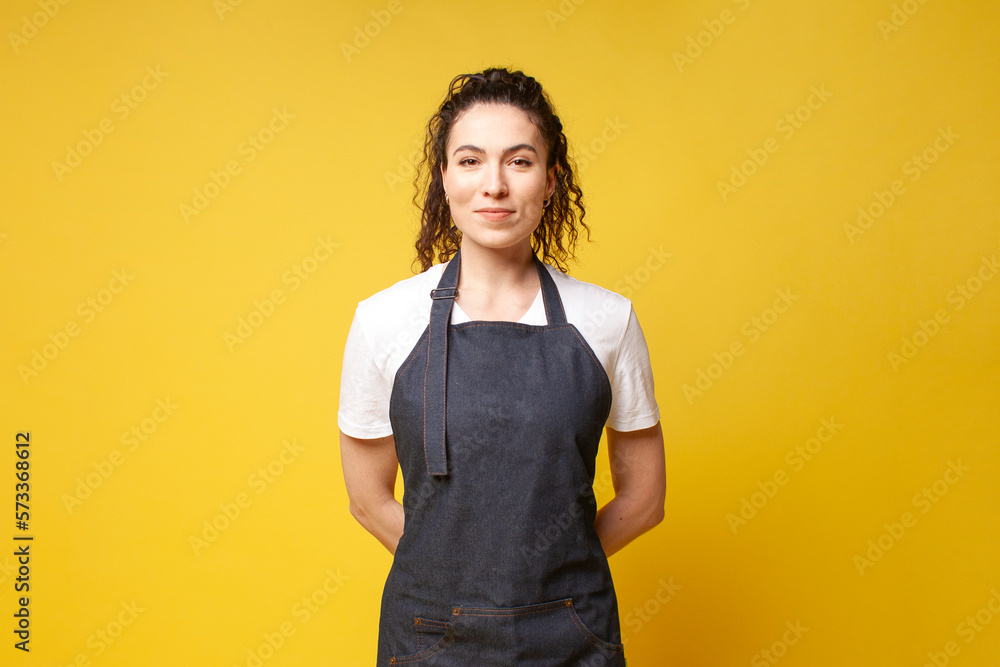 girl waiter in uniform stands with her hands behind her back on a ...