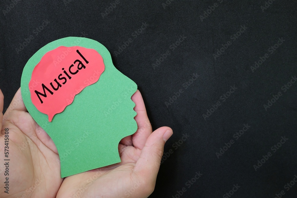 Musical intelligence in psychology concept. Hand holding human head ...