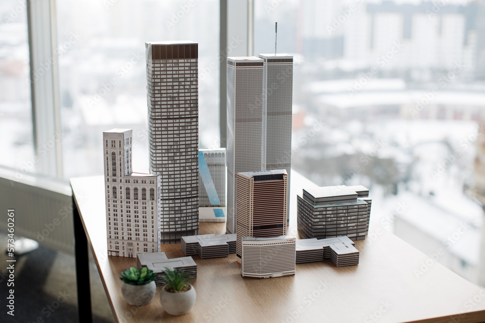Table with white architectural scale cardboard model of building ...