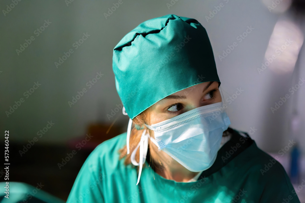 female caucasian surgeon working operating room. female nurse wear mask ...