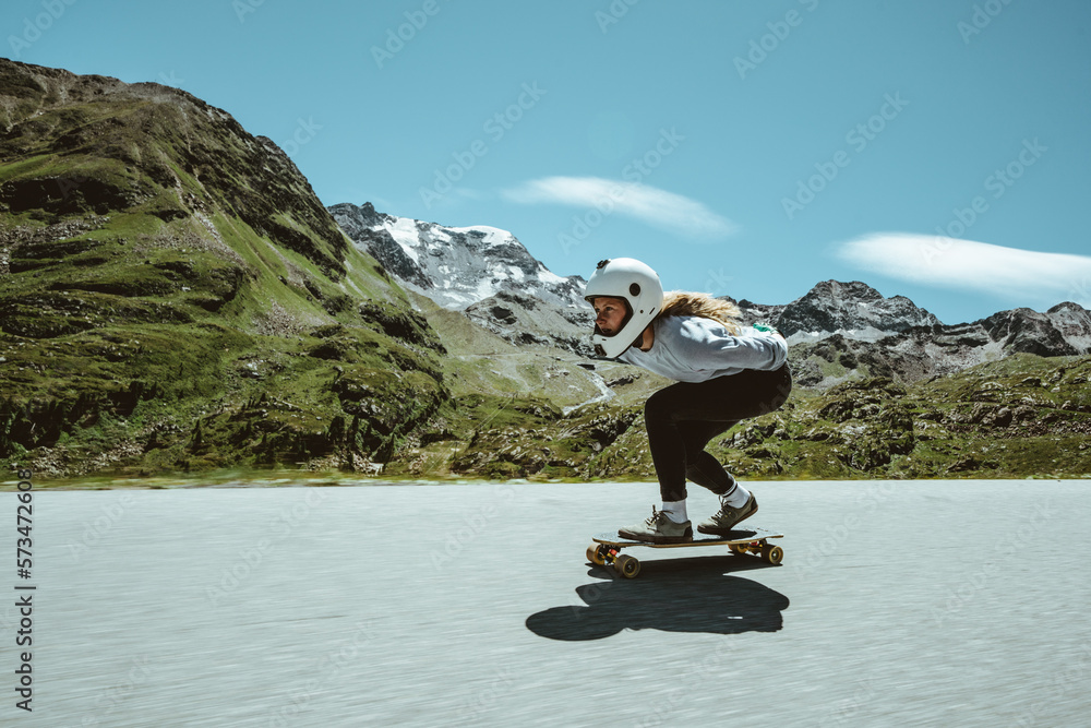 Foto de Cinematic downhill longboard session. Young woman skateboarding ...