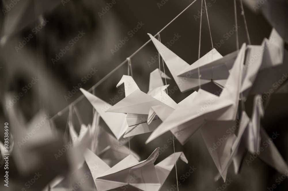 Japanese folded Origami cranes hanging on with strings. Hundreds ...