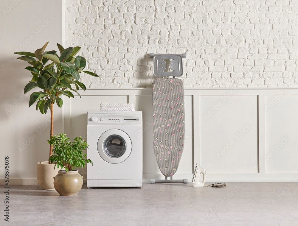 Washing machine in the bathroom, white brick wall background, vase of ...